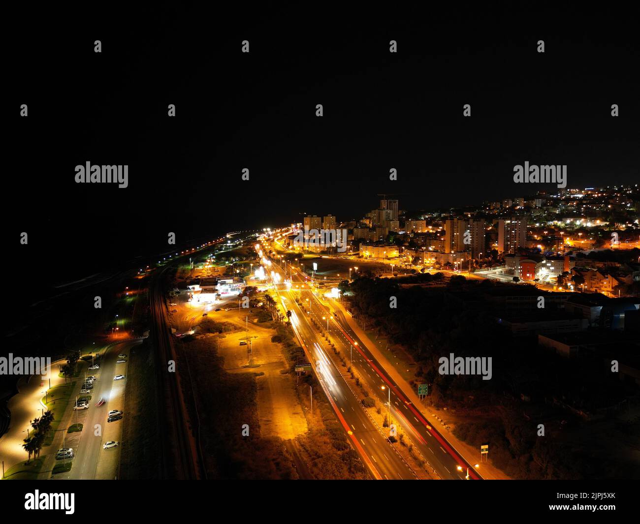 An aerial view of an illuminated highway by the city at night Stock ...