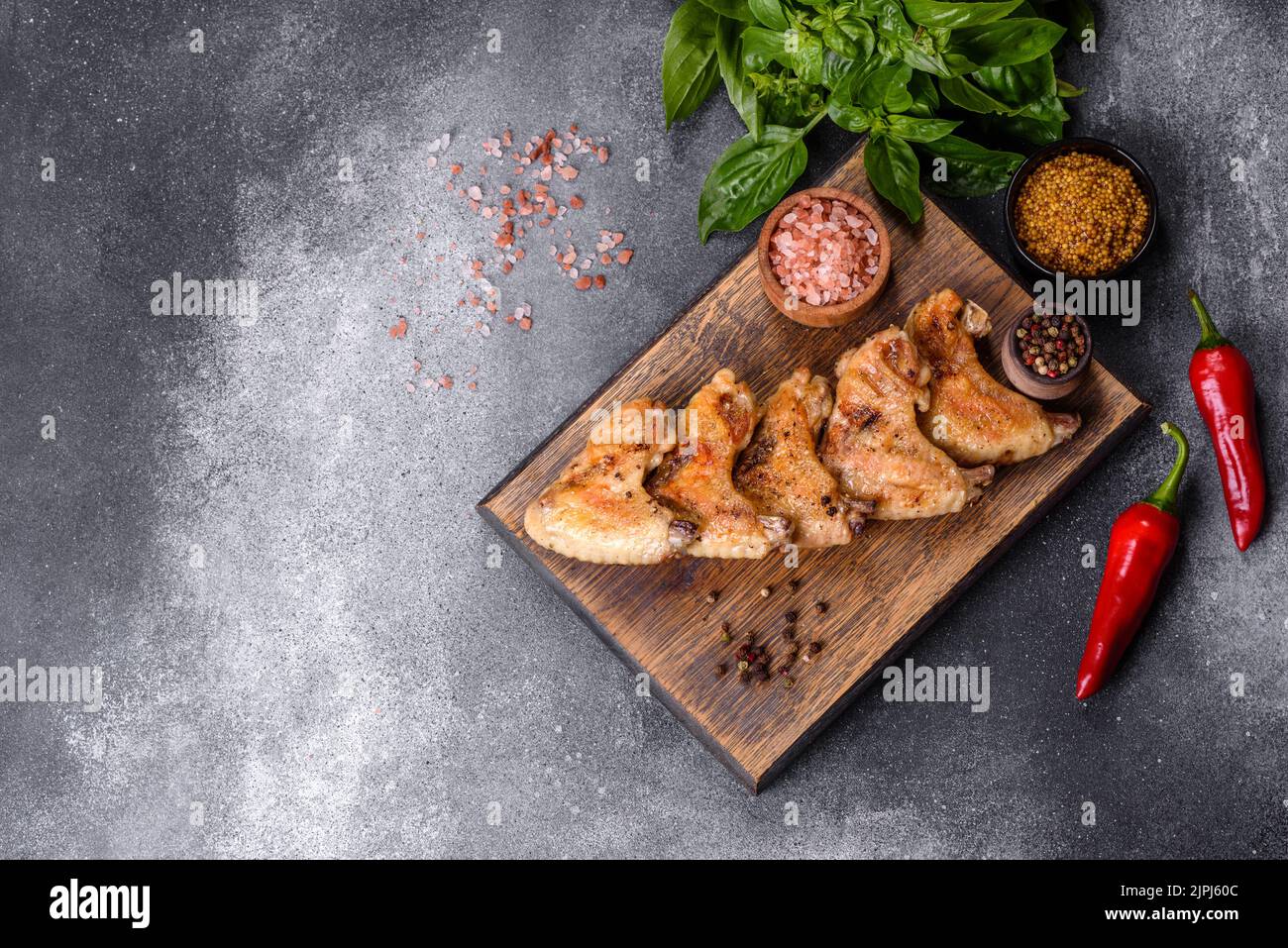 Baked chicken wings served with different sauces and lemon. Gray ...