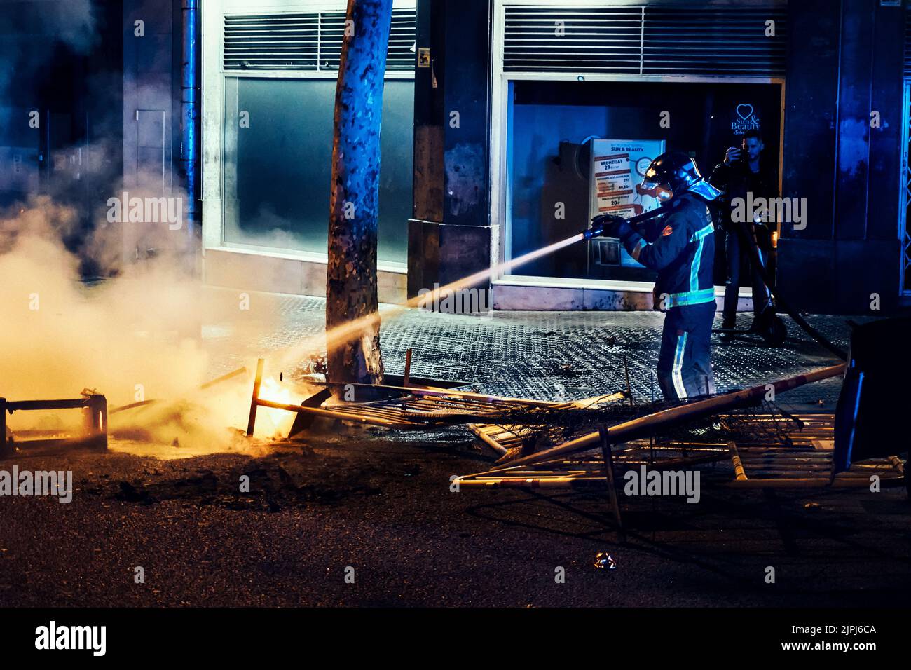Firefighter putting out a fire started by a protester Stock Photo - Alamy