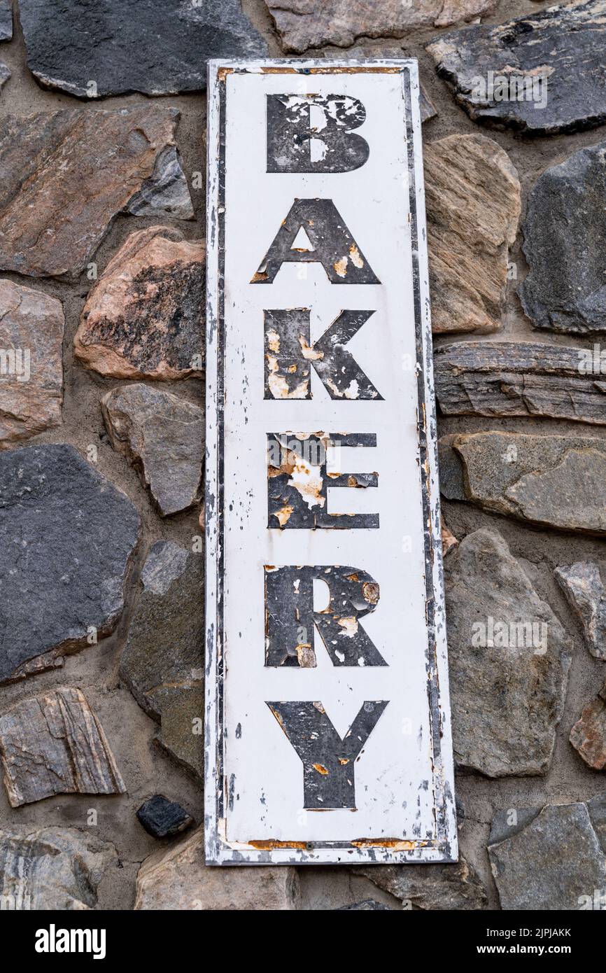 Old rustic bakery sign against a stone wall Stock Photo - Alamy