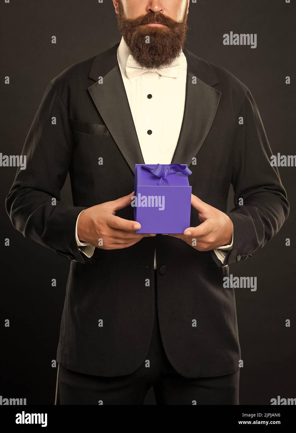 cropped bearded man in tuxedo hold present box, shopping Stock Photo ...