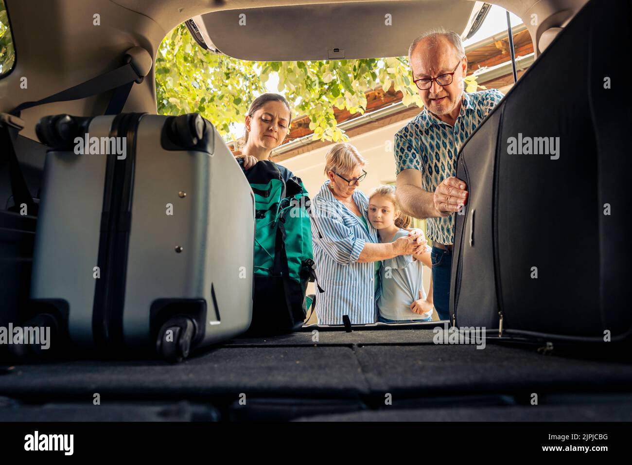 People loading suitcase and luggage in trunk, preparing to travel on ...