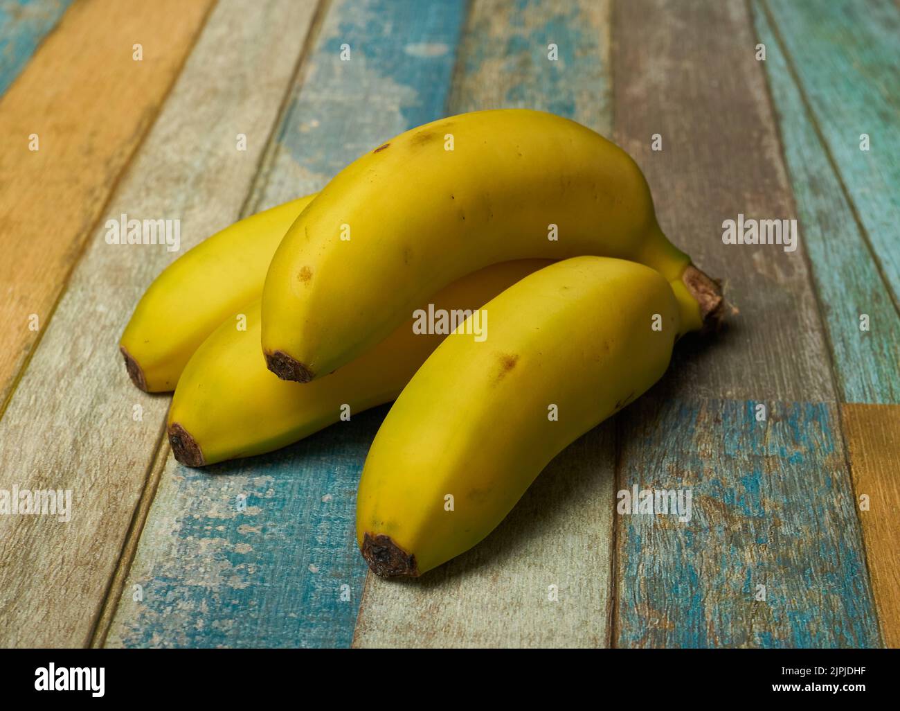 A selective focus shot of Lady Finger bananas on a wooden table Stock ...