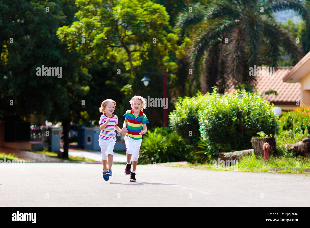 Kids running. Children run on city suburbs street on sunny summer day ...