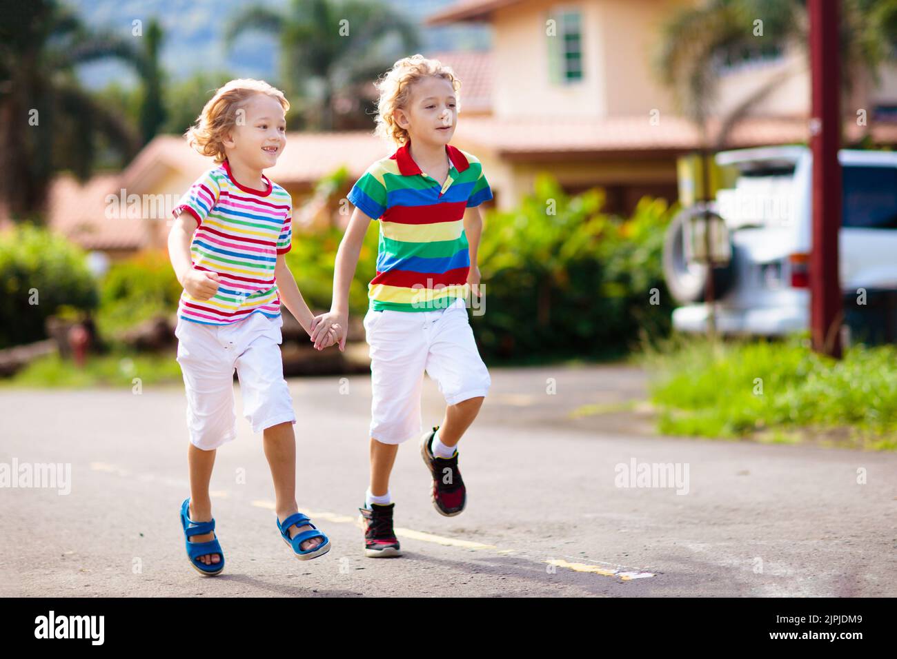 Kids running. Children run on city suburbs street on sunny summer day ...