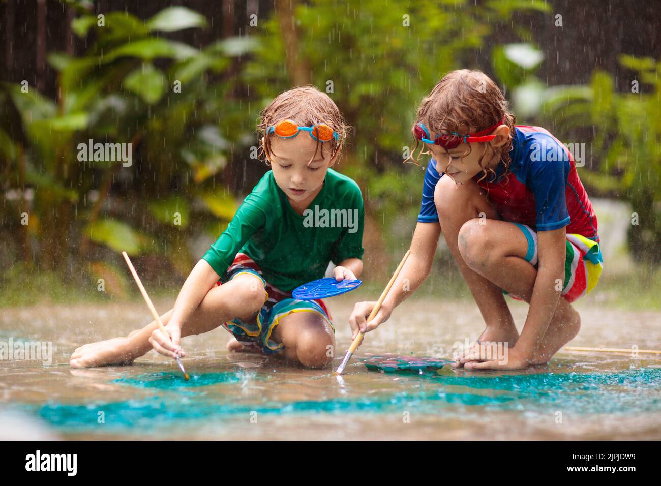 Kids playing in the rain. Chalk drawing fun. Art and crafts for young ...