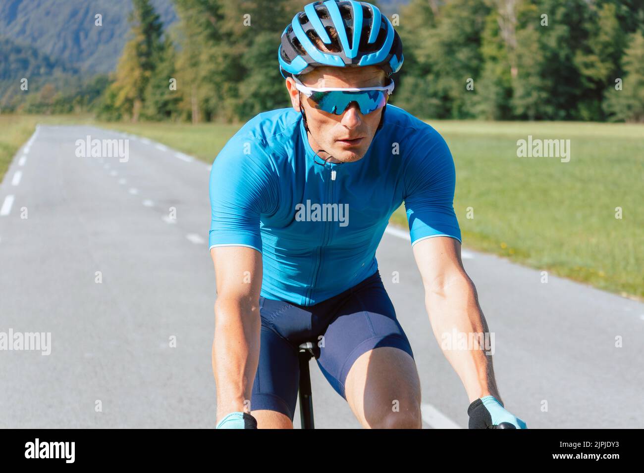 Male professional road cyclist during a race in blue dress Stock Photo ...