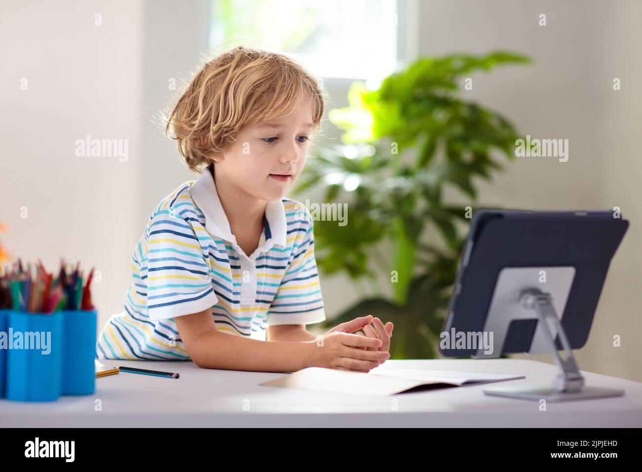 Online remote learning. School kids with computer having video conference chat with teacher and ...