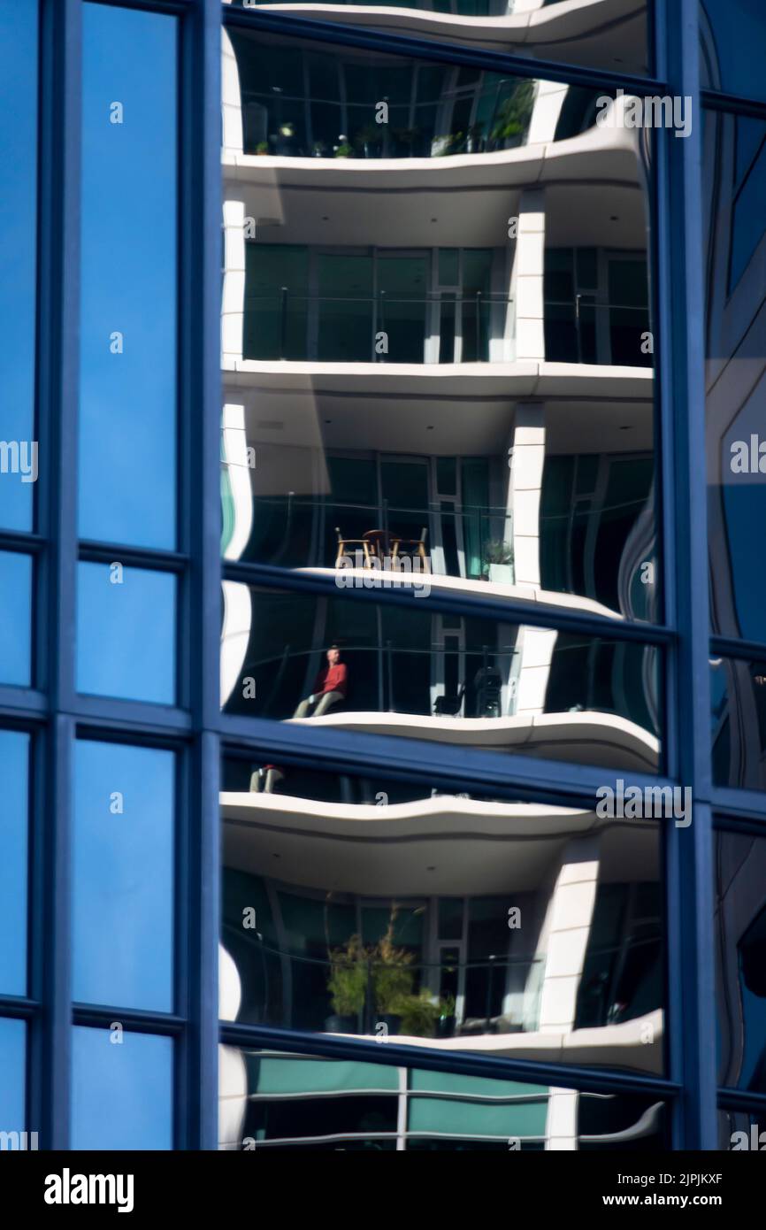 Apartment balconies reflected in glass office building, Wellington ...