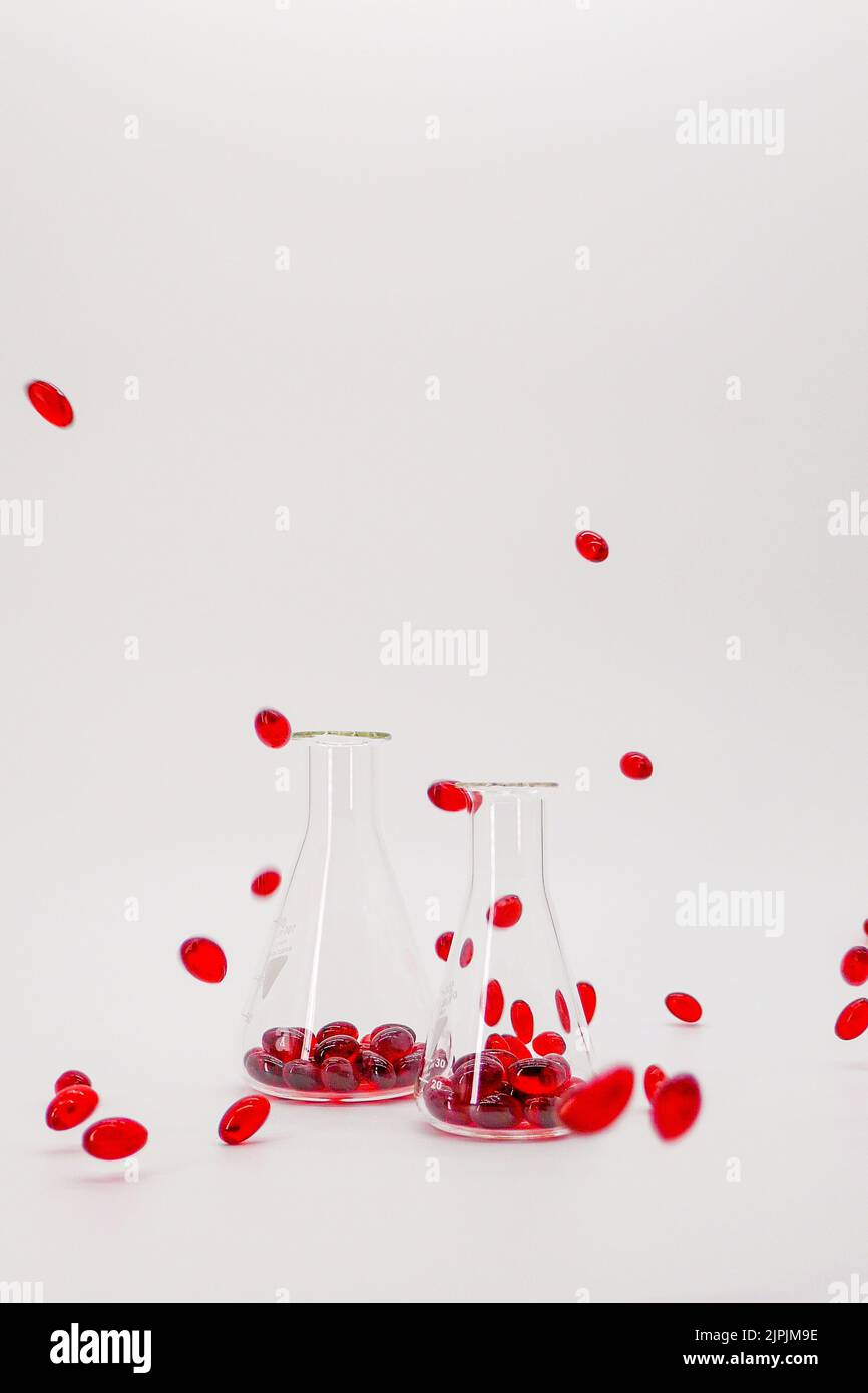 Krill oil in laboratory transparent flasks on a white background ...