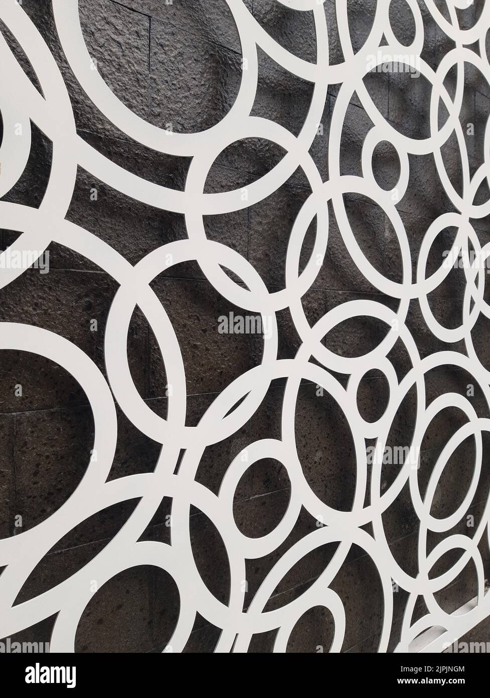 A vertical closeup of a decorative panel with circles on a wall Stock ...