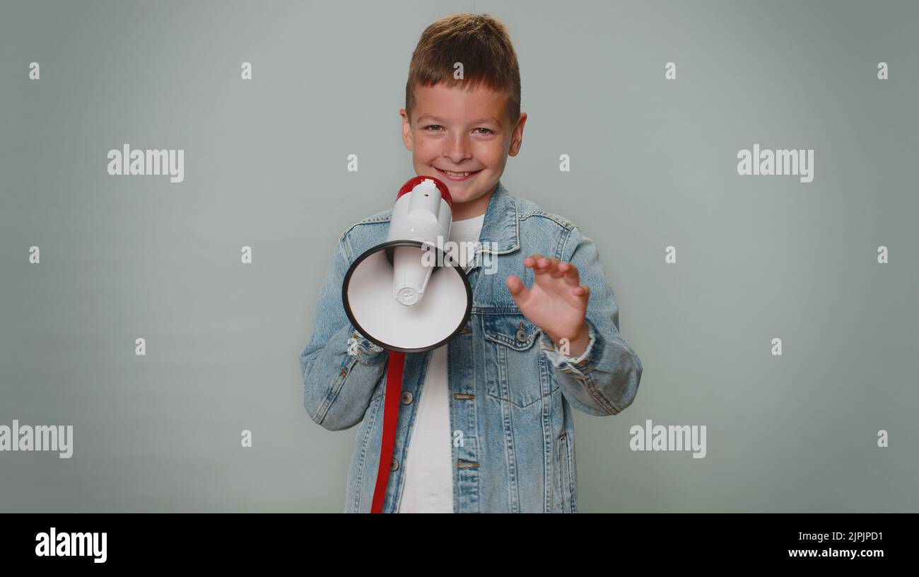 Smiling happy toddler boy talking with megaphone, proclaiming news ...
