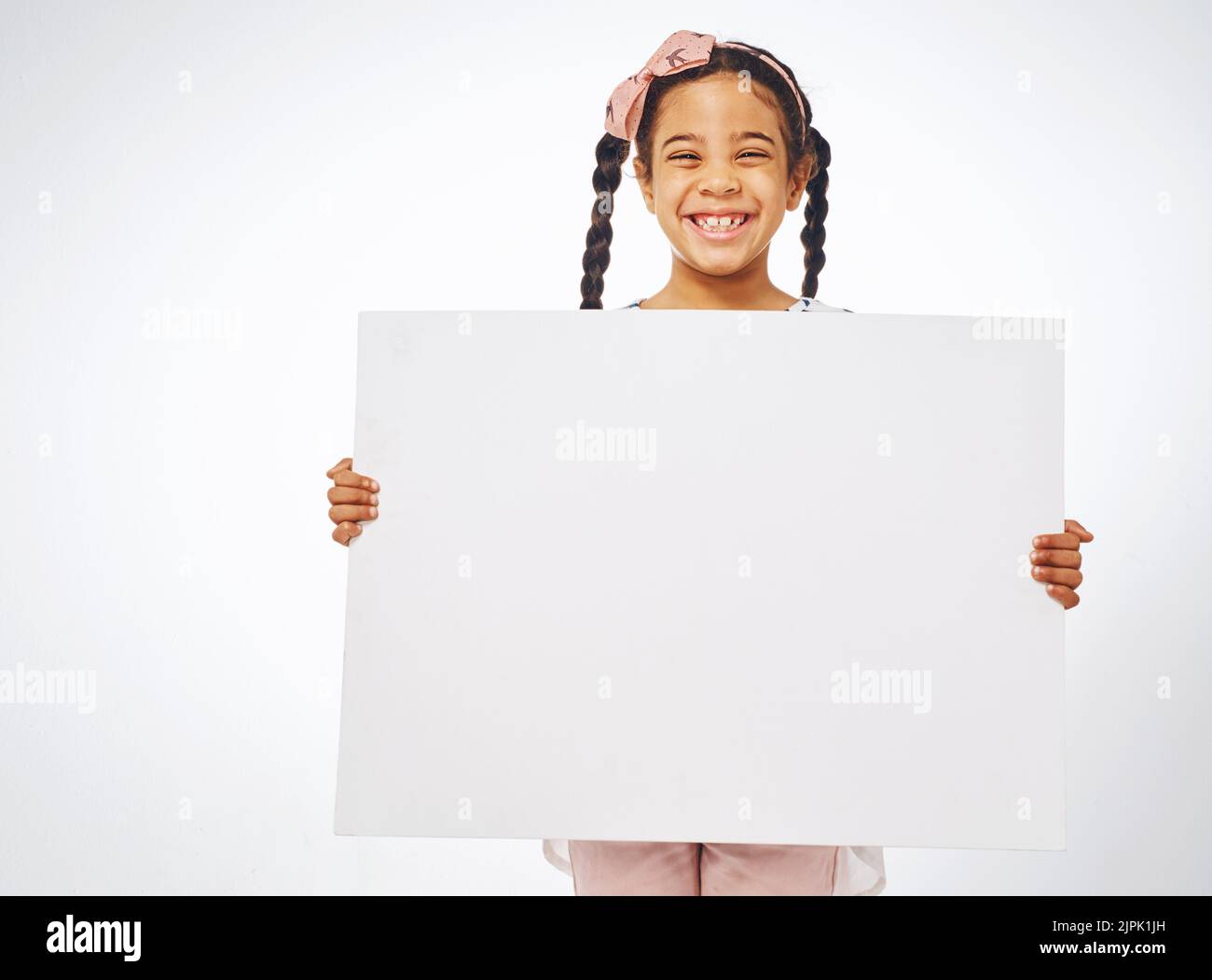 Put a smile on your kids face. Studio shot of an adorable little girl ...