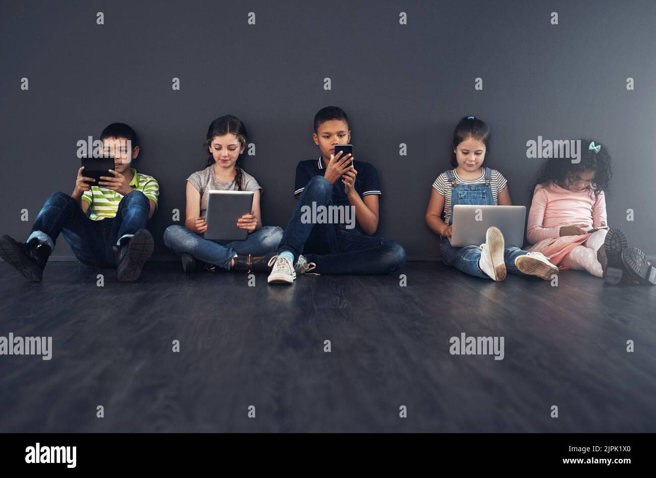 Learning to be technology literate. Studio shot of kids sitting on the ...