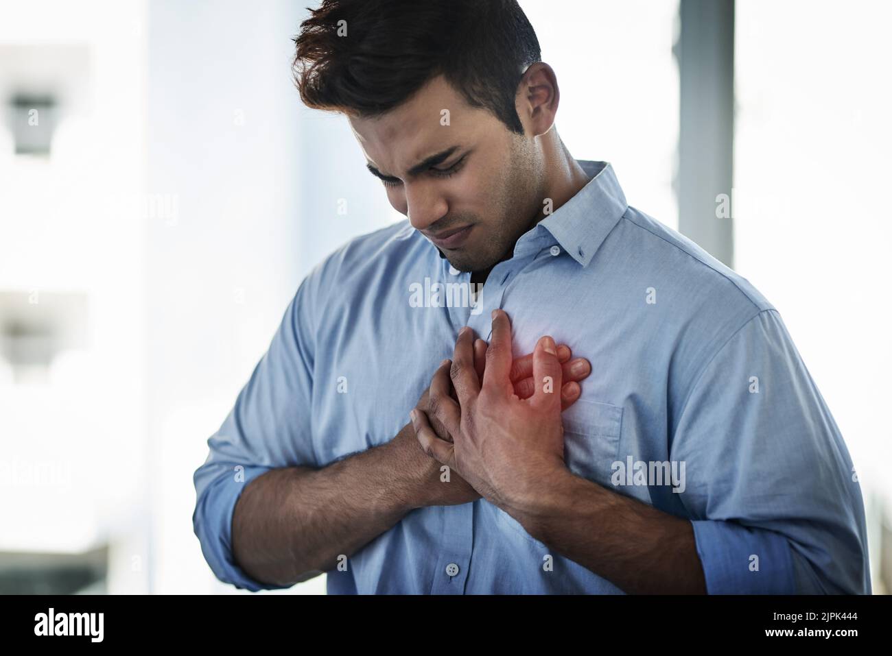 Feels like a sharp jab at my chest. a young businessman suffering with ...