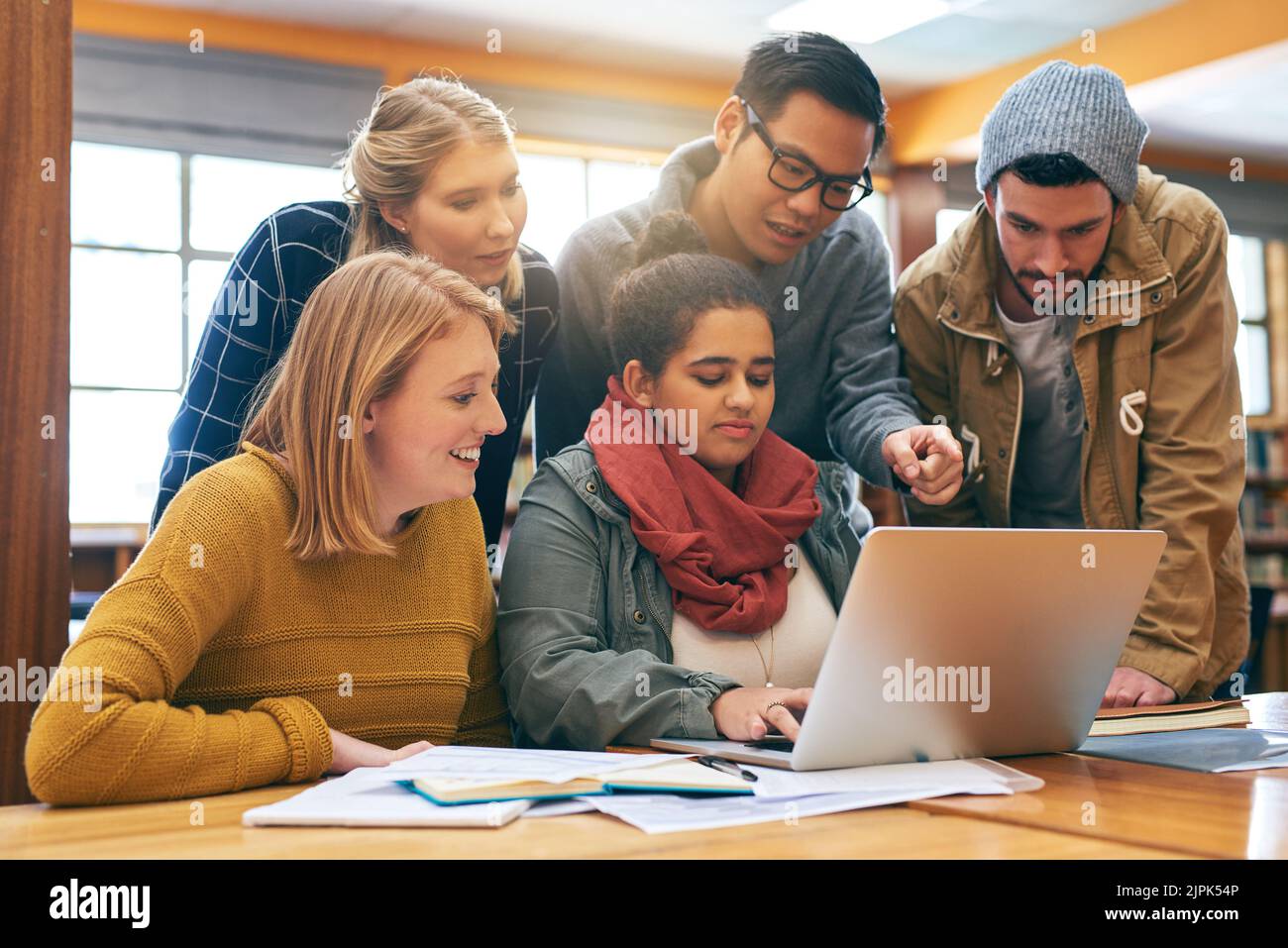 Everyone trying to solve a problem together. a cheerful young group of ...