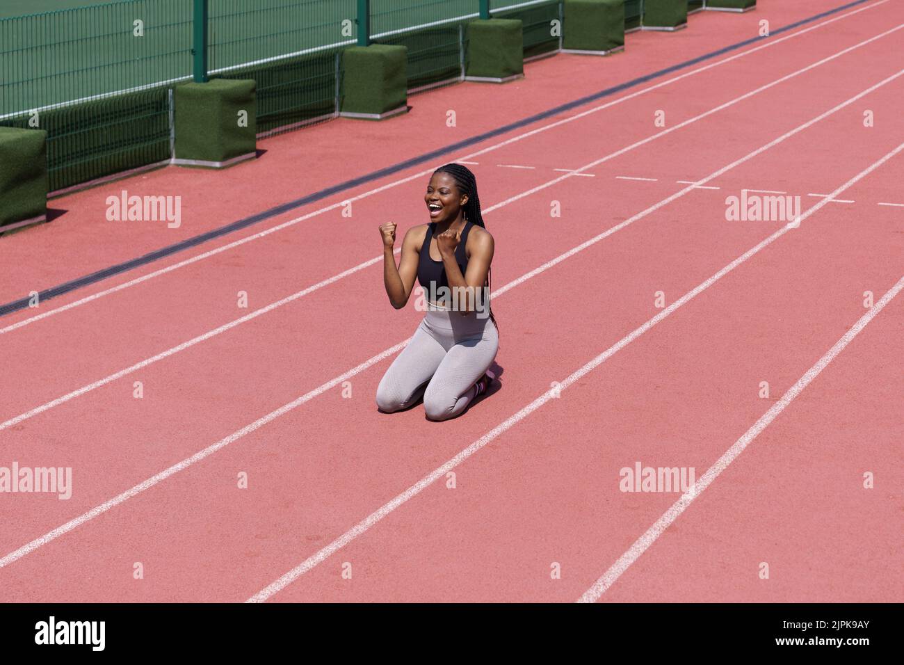 Black professional female athlete in sportswear rejoices with success ...