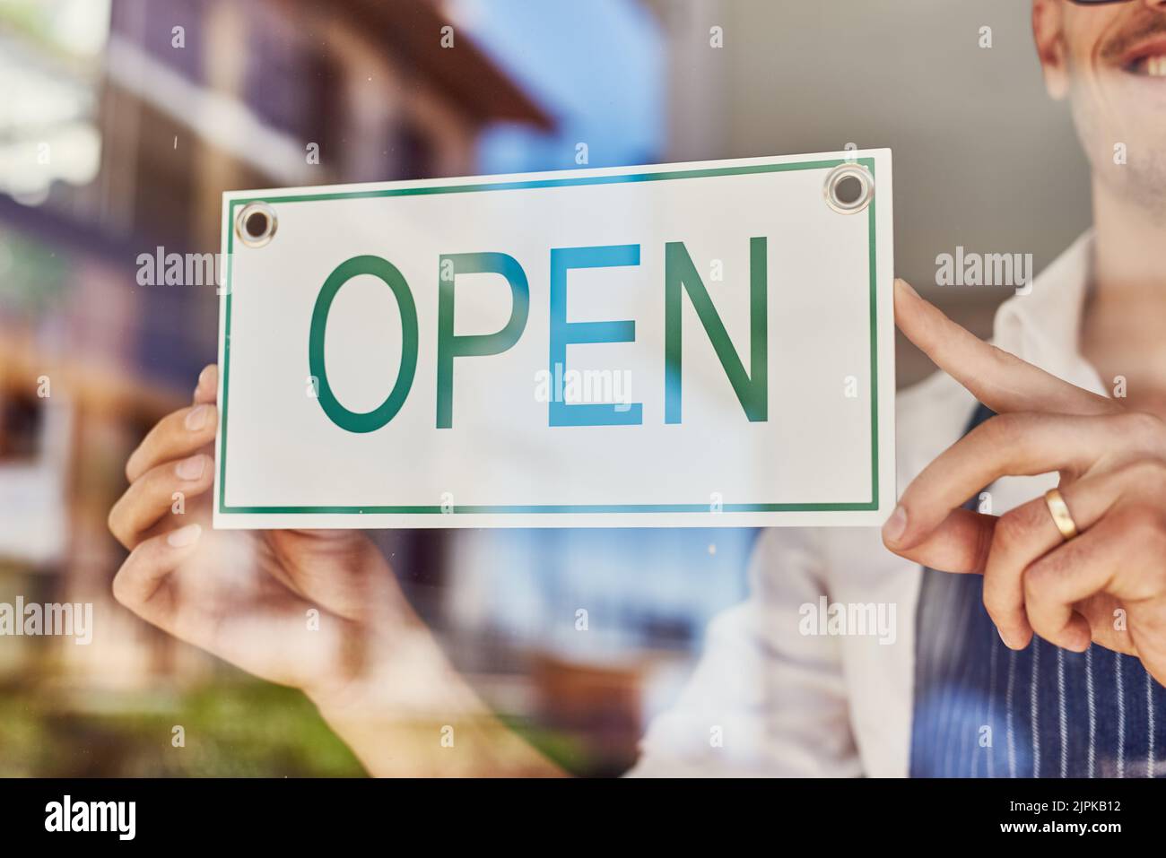 Were open, come inside. an unrecognizable man putting the open sign up ...
