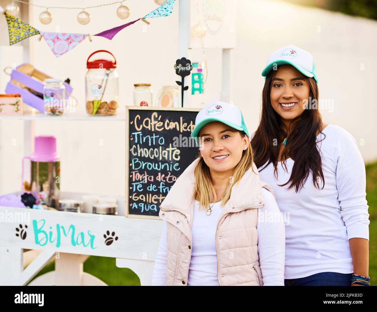 We are open and ready to sell. Portrait of two cheerful young women ...