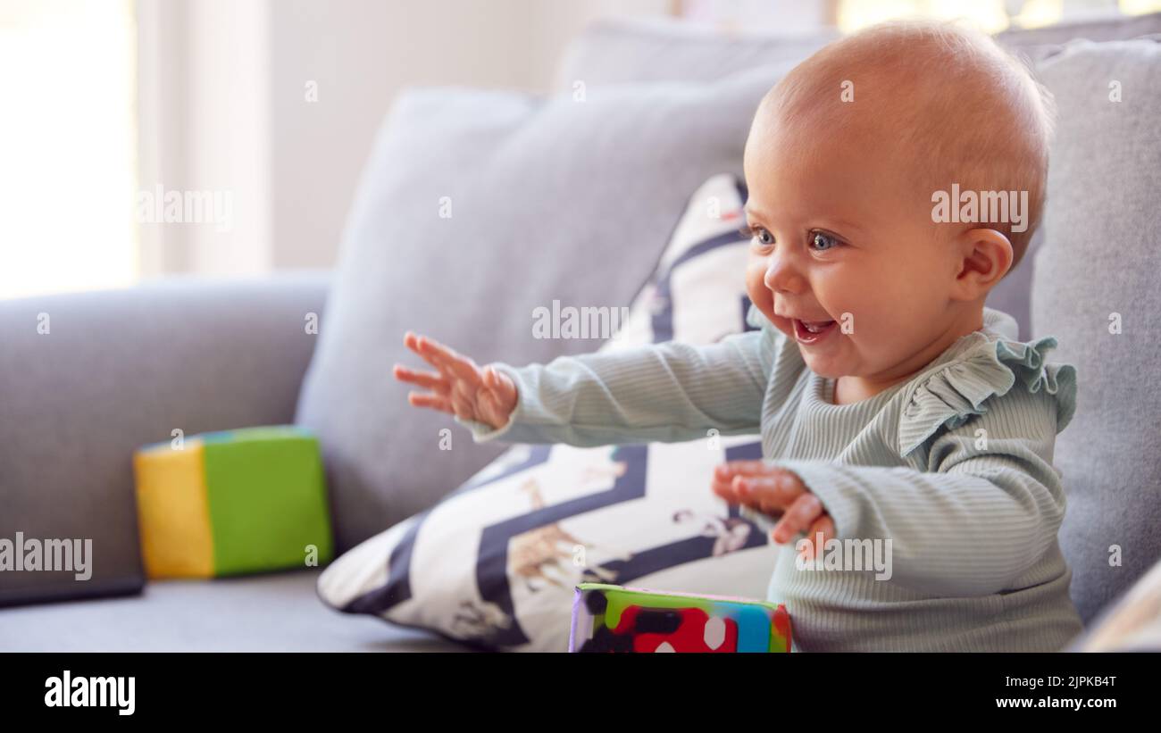 Baby reaching toy hi-res stock photography and images - Alamy