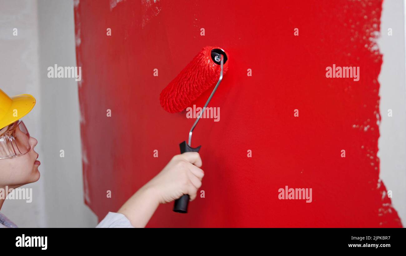 A little boy painting wall with red paint Stock Photo - Alamy