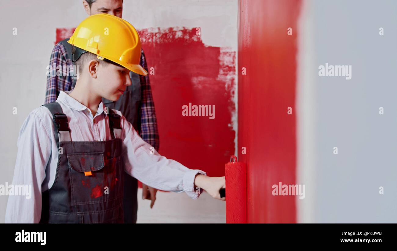 Repairing draft apartment - little boy and his father painting wall in ...