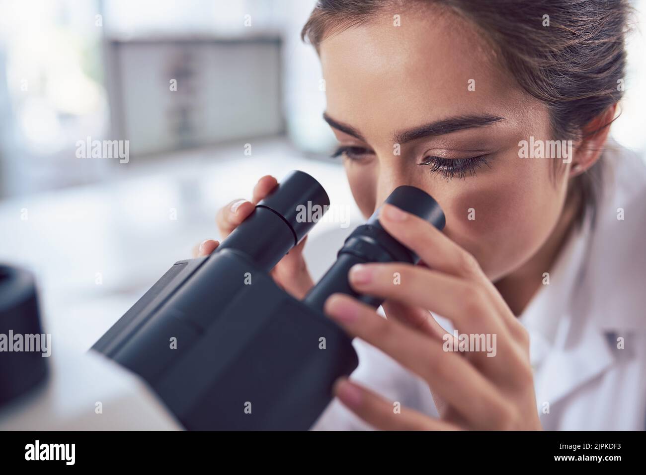A detailed point of view. Closeup of a focused young female scientist ...