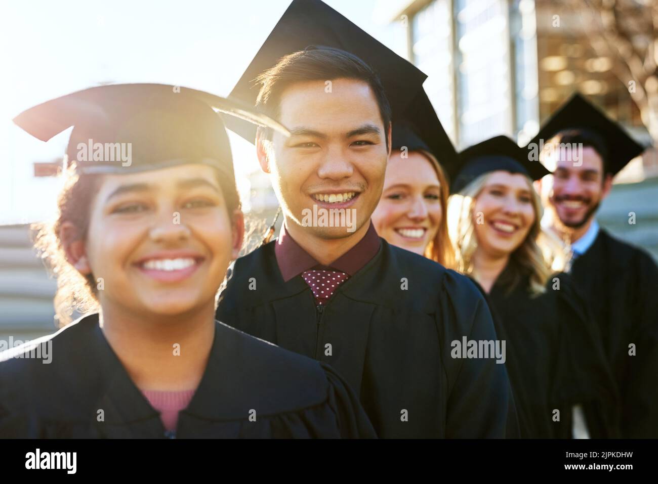 Our proudest moment. Portrait of a group of students standing in a line ...