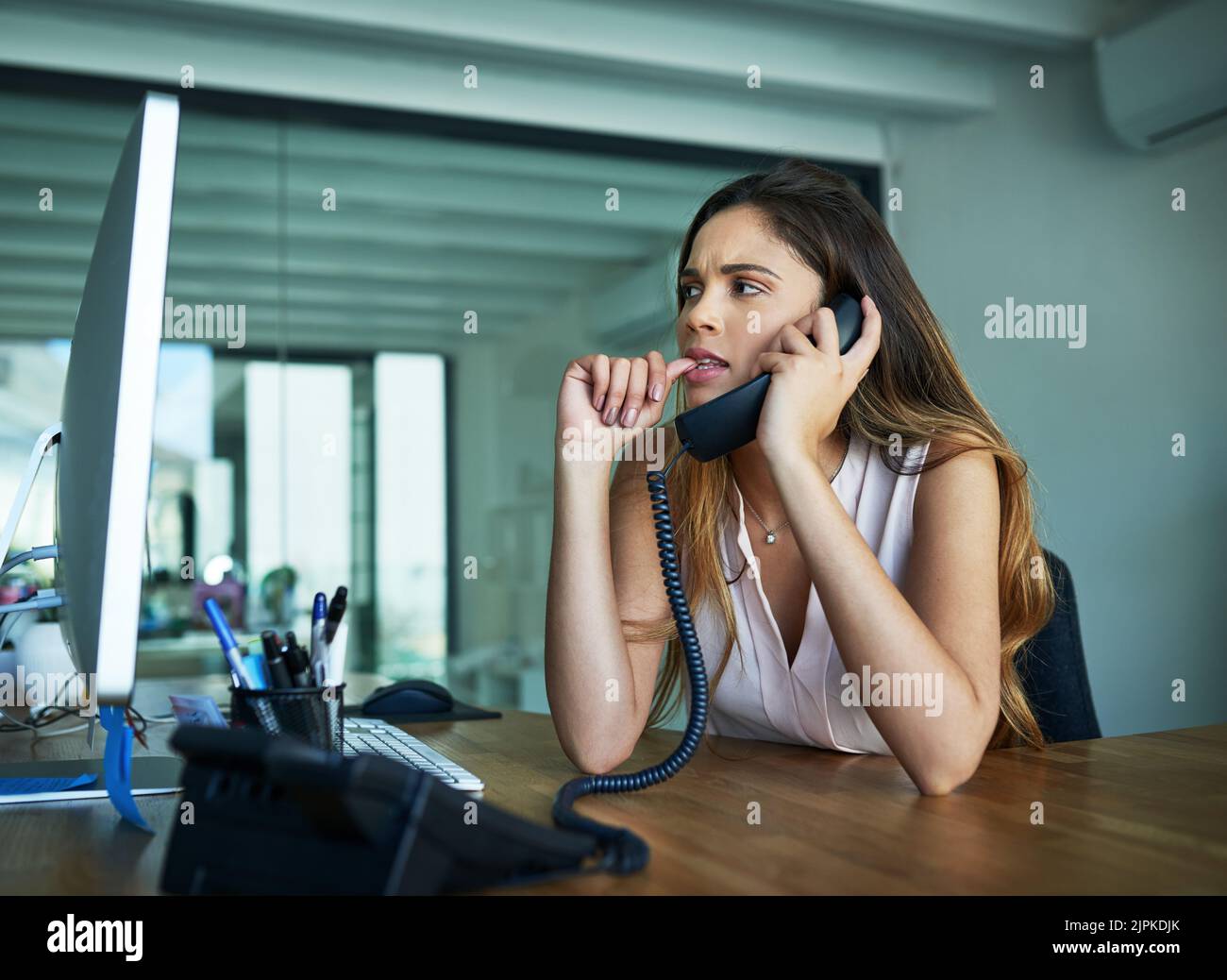 Sometimes anxiety gets the best of her. a young businesswoman biting ...