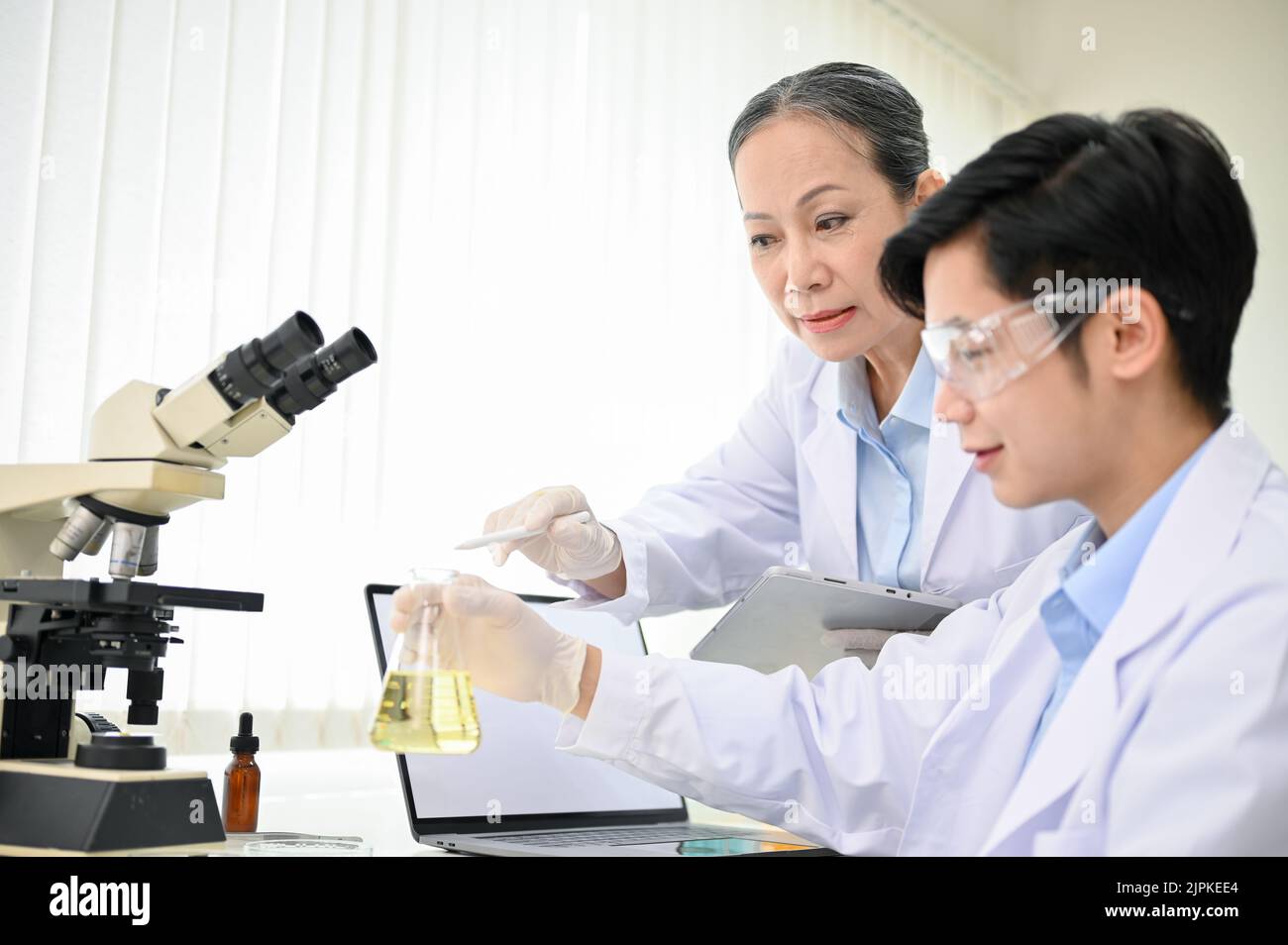 Professional Asian middle-aged female scientist training and giving an ...