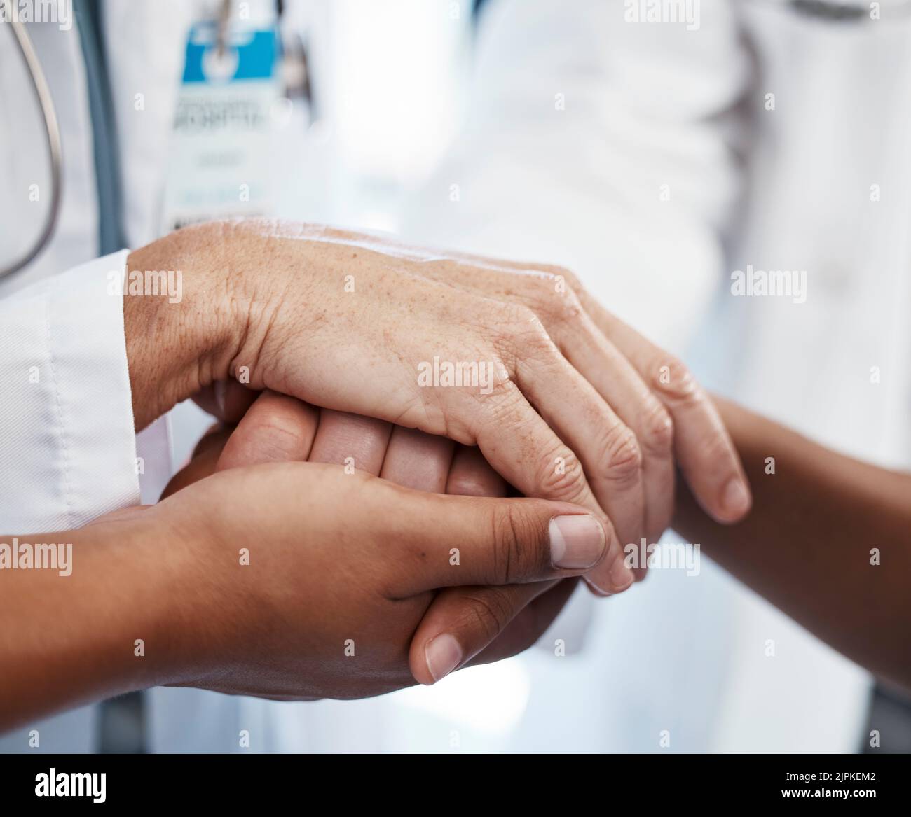 Doctor, holding a patients hands and comforting them after the loss of ...