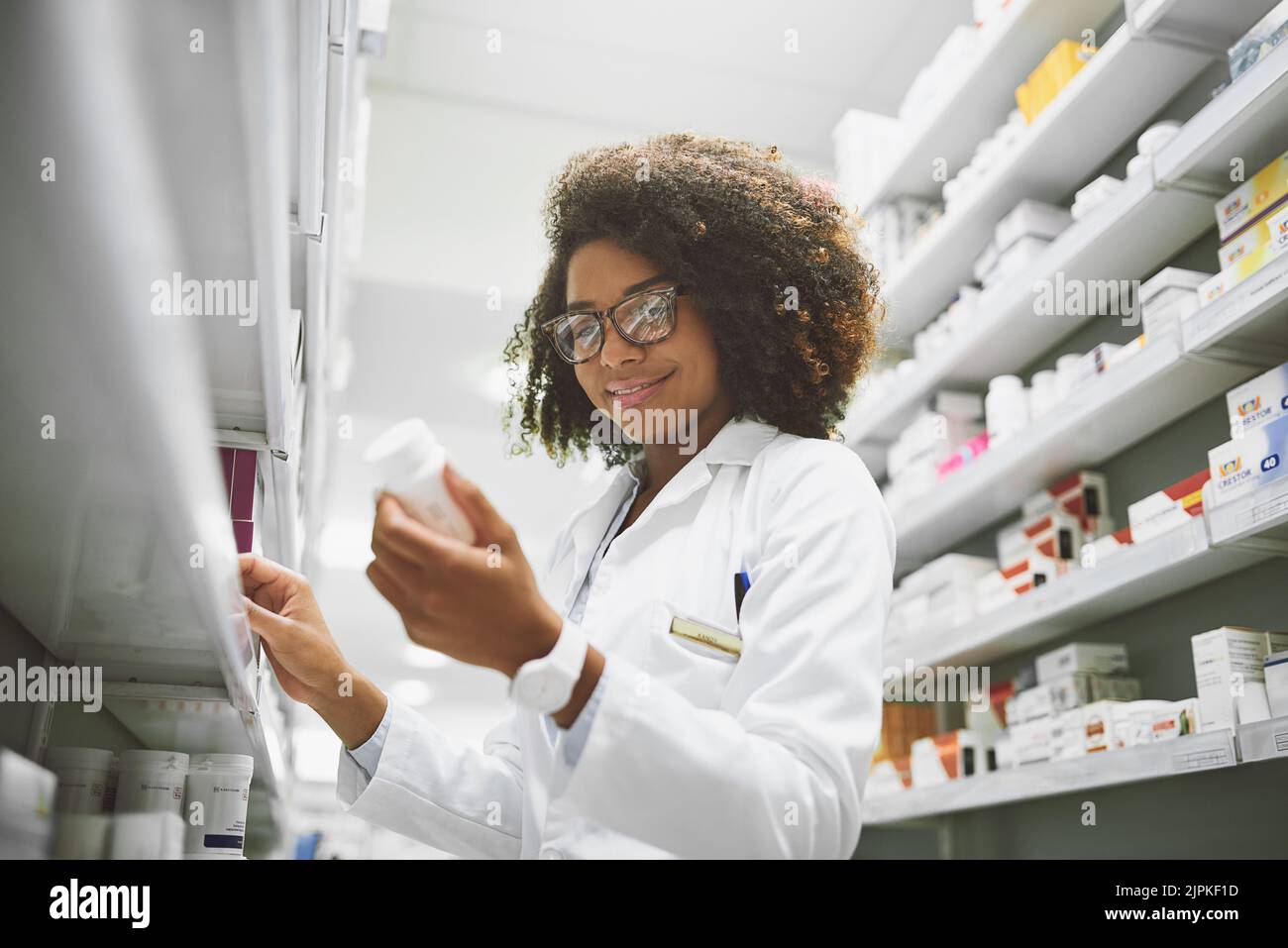 Always read the label. a cheerful young female pharmacist reading the ...
