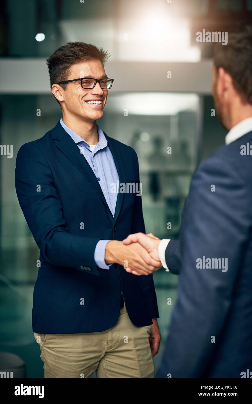 Its great to meet you. two handsome businessmen shaking hands in an ...