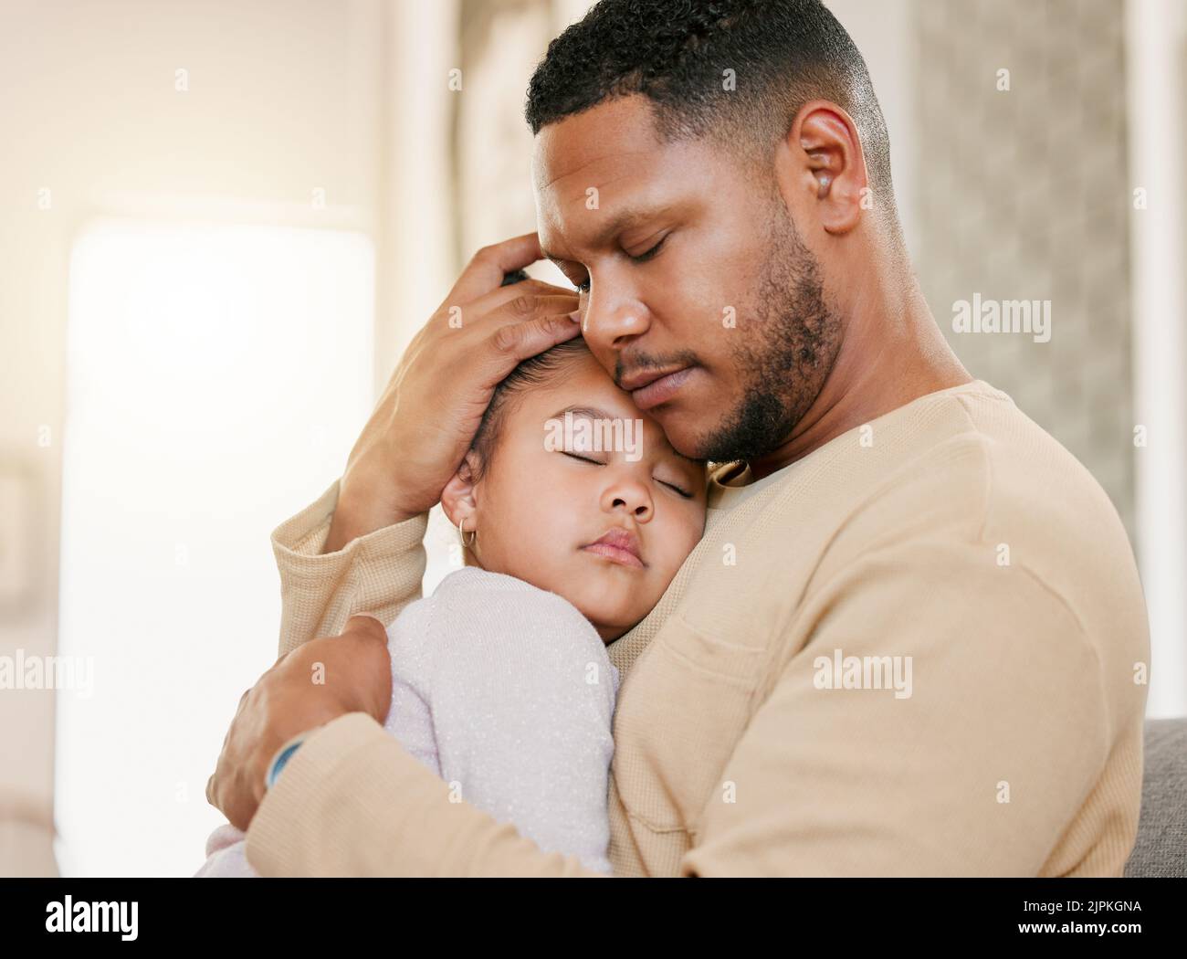 Father hugging sleeping daughter, caring for sick child and family giving loving embrace at home ...
