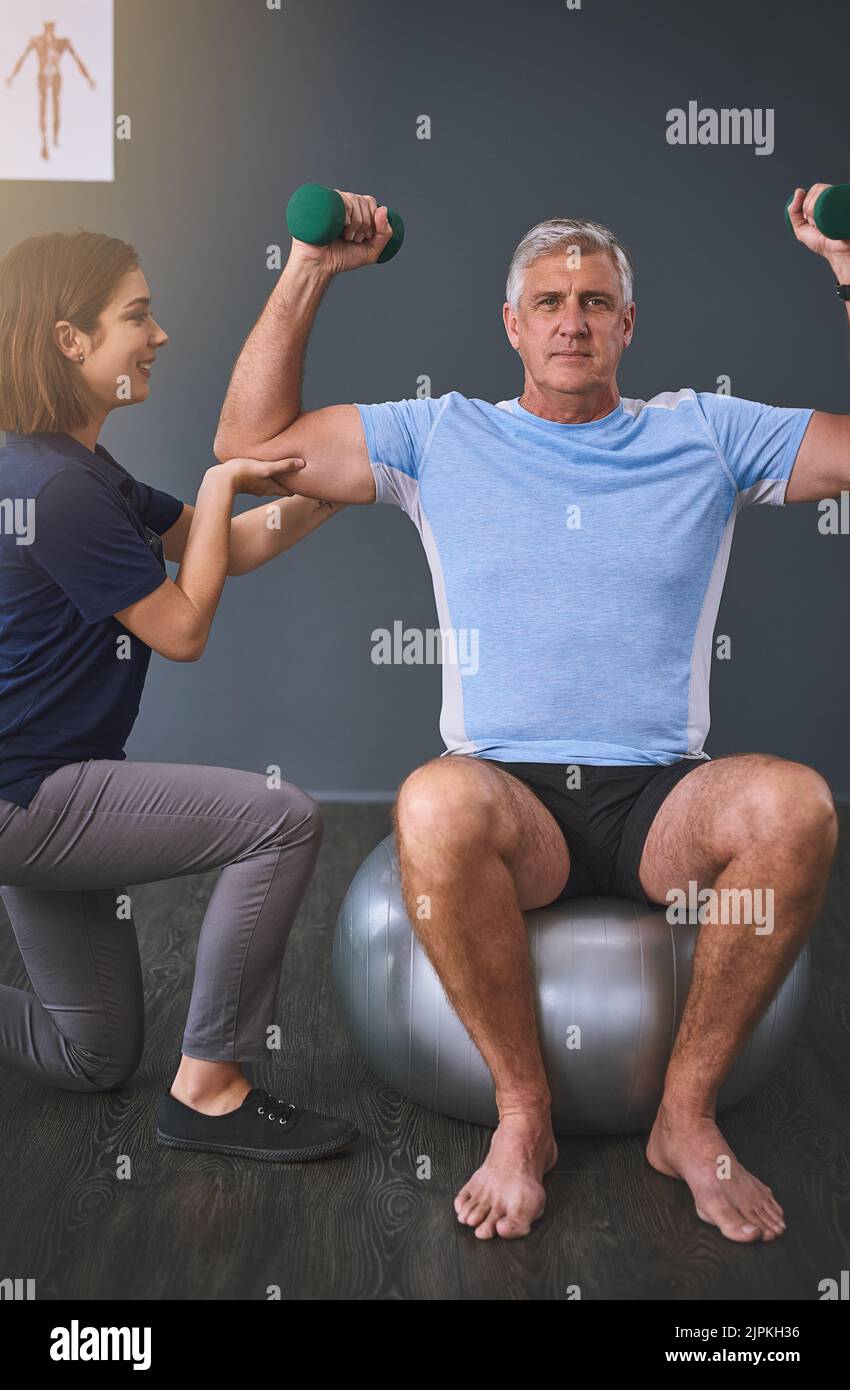 Working on staying strong. a female physician working with a senior ...