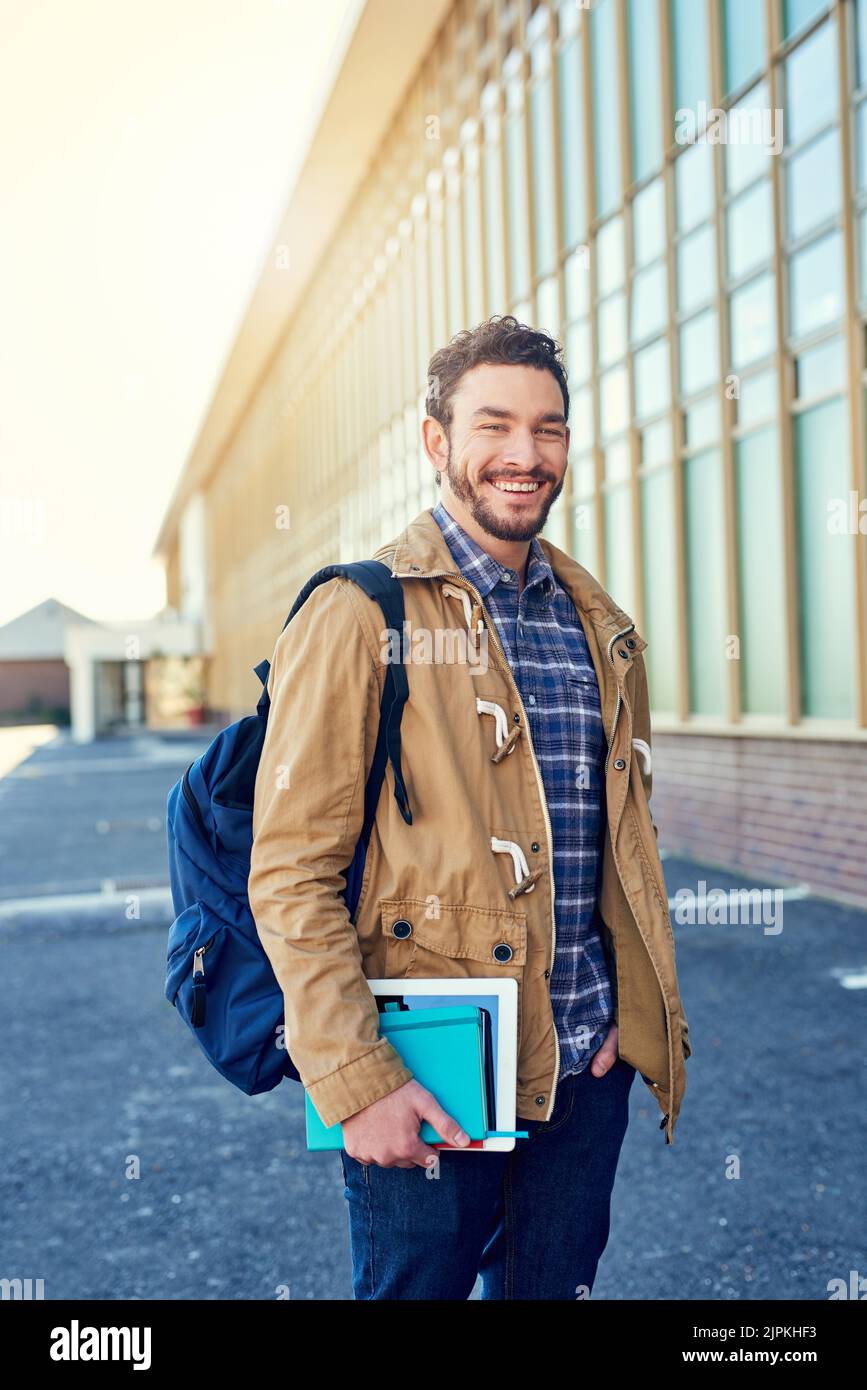 Eager for his first class. a college student between classes on campus ...