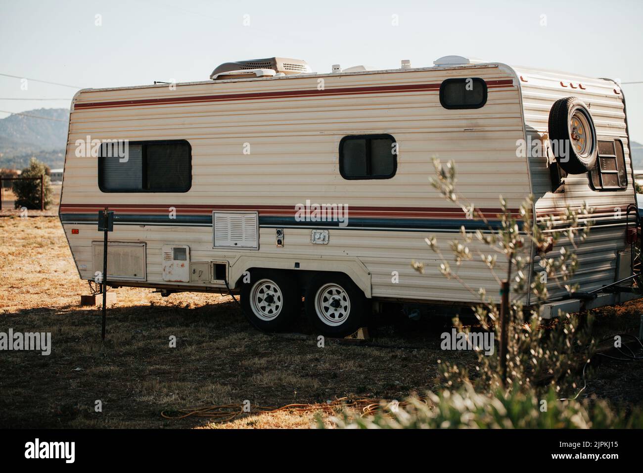 Old trailer parked on camping grounds Stock Photo - Alamy