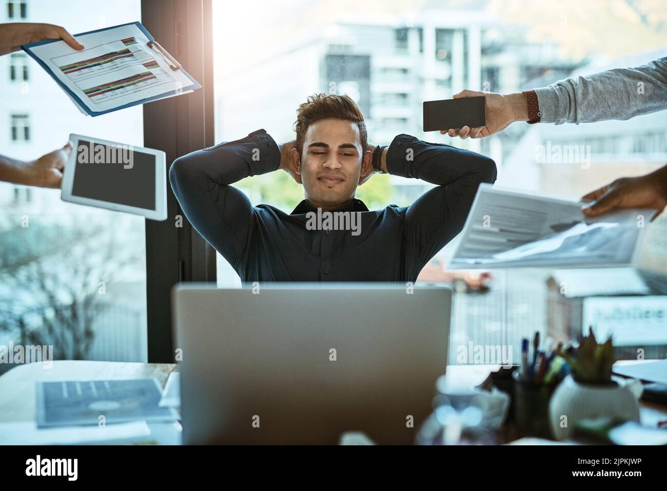 Staying calm and collected throughout the workday. a young businessman ...