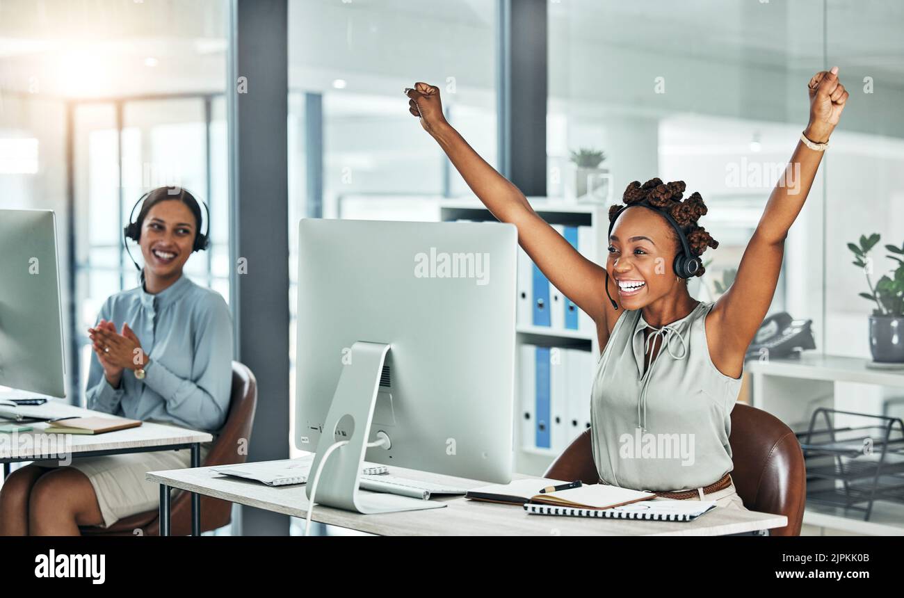 Call centre, cheerful and agent celebrating with arms up at her office ...