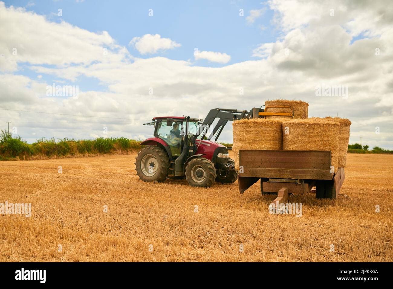 These hay bales wont stack themselves. a farmer stacking hale bales ...