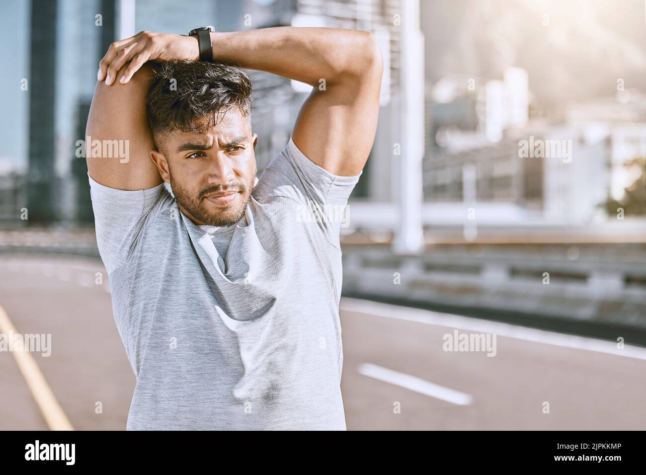 Man doing warmup stretch before running in urban city street, getting ...