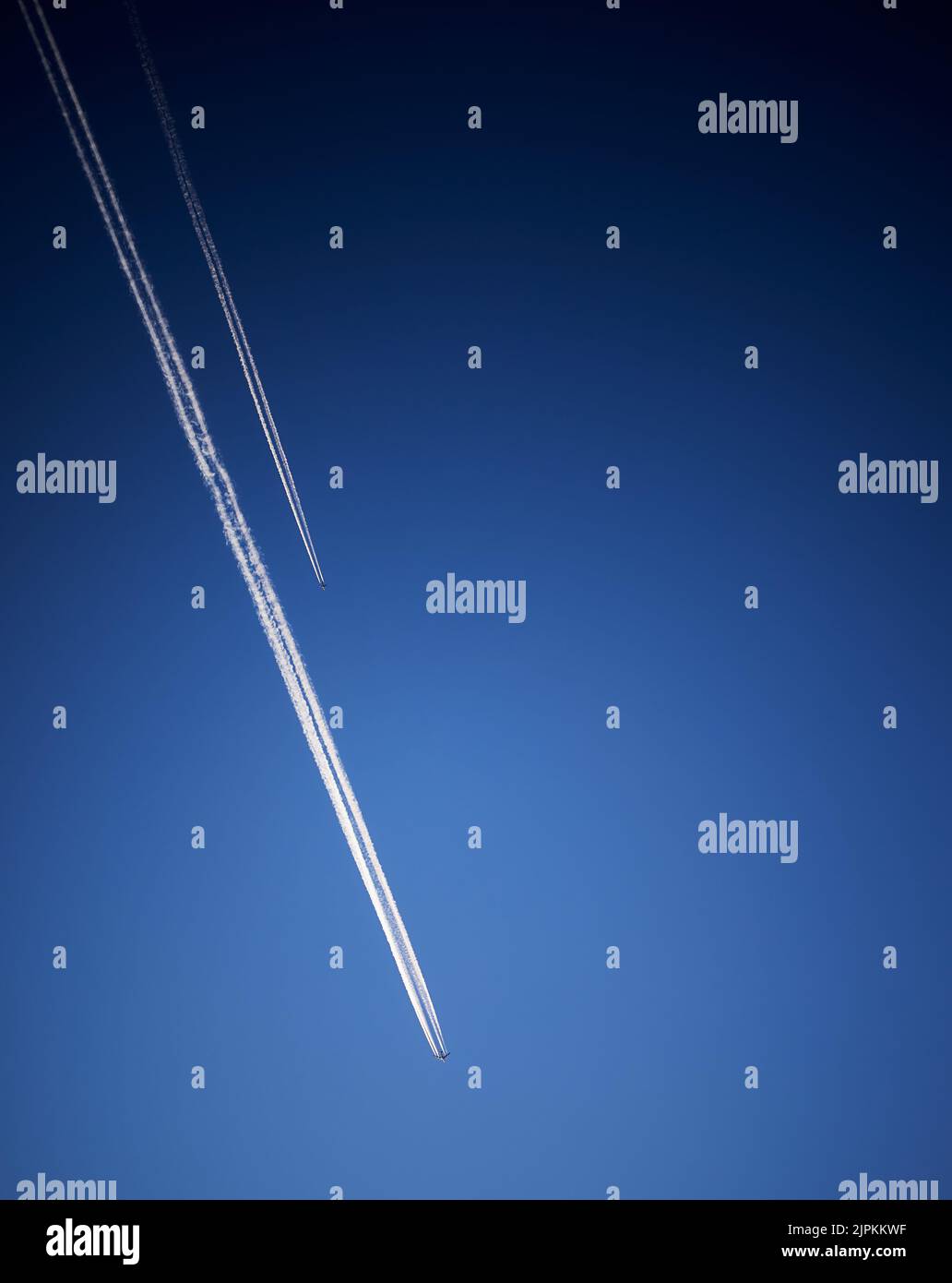 The vertical view of two aircraft with contrails in the blue sky Stock Photo - Alamy