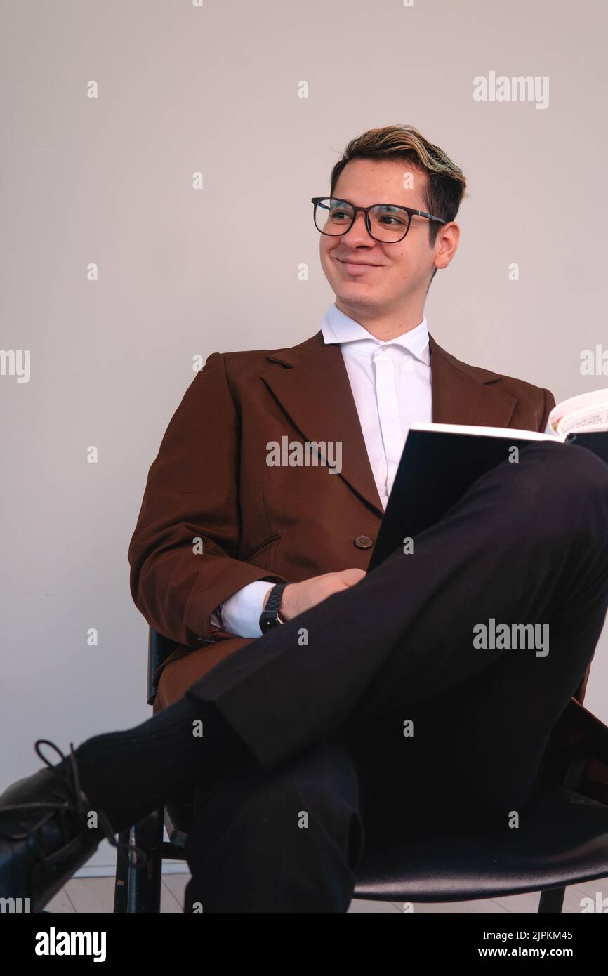 A college professor in a suit sitting down smiling. Happy lawyer on a ...