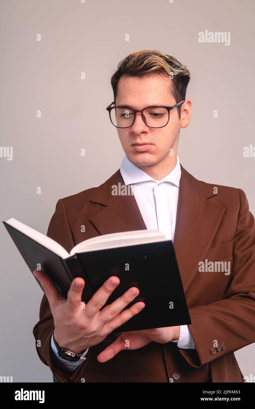 Intellectual man reading a book very attentively on a white background ...