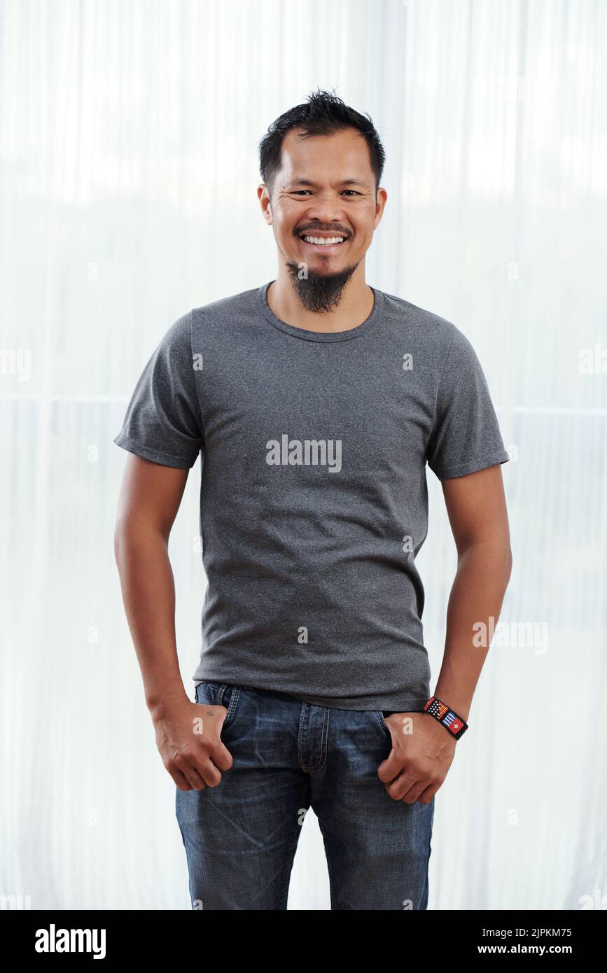 Portrait of smiling happy Filipino man on light background Stock Photo ...