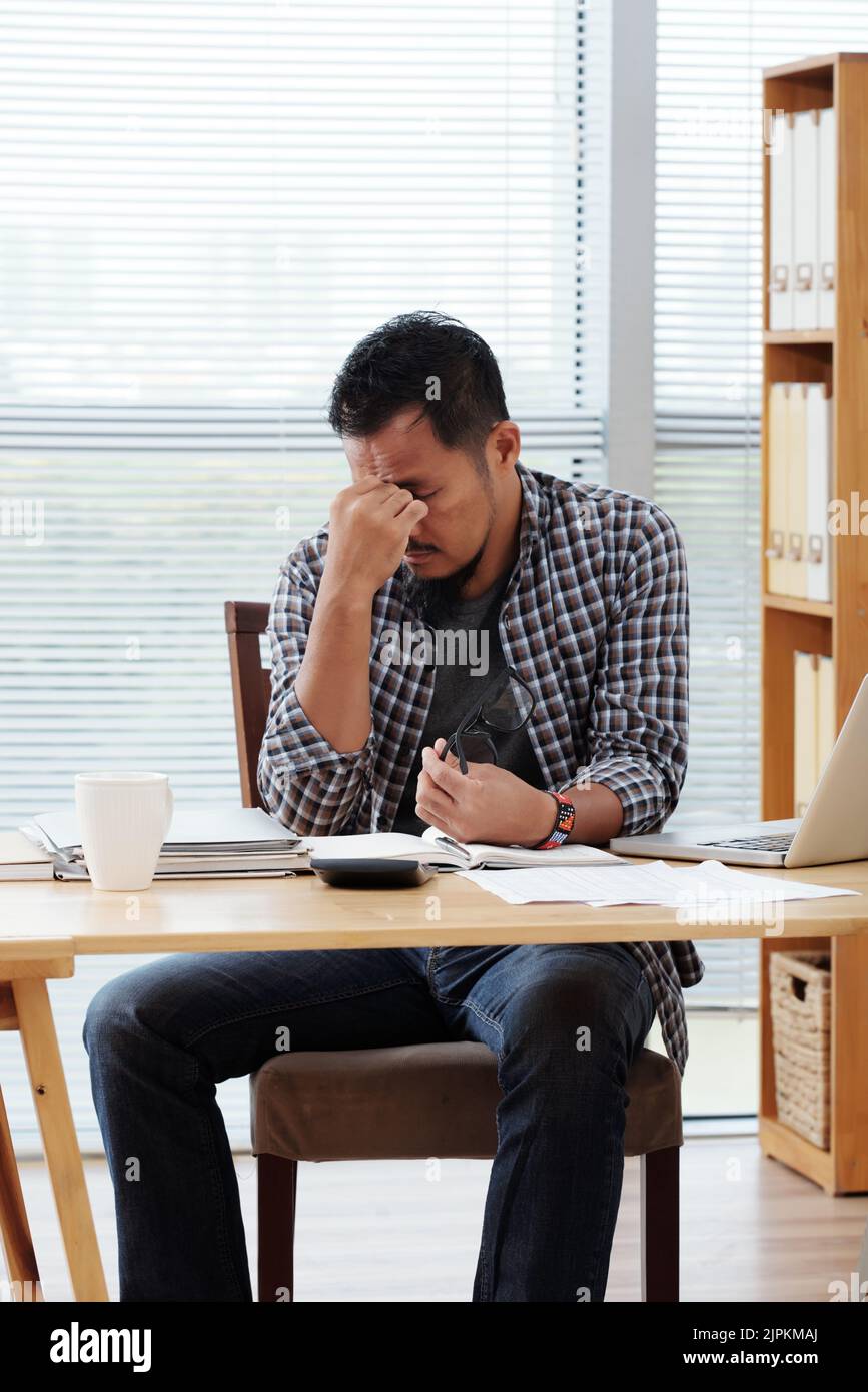 Frustrated Filipino business executive at his office table Stock Photo ...