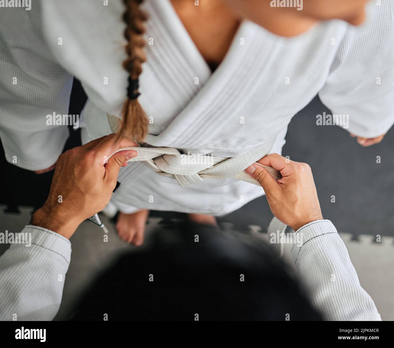 Woman wearing karate belt at fitness training class from coach ...