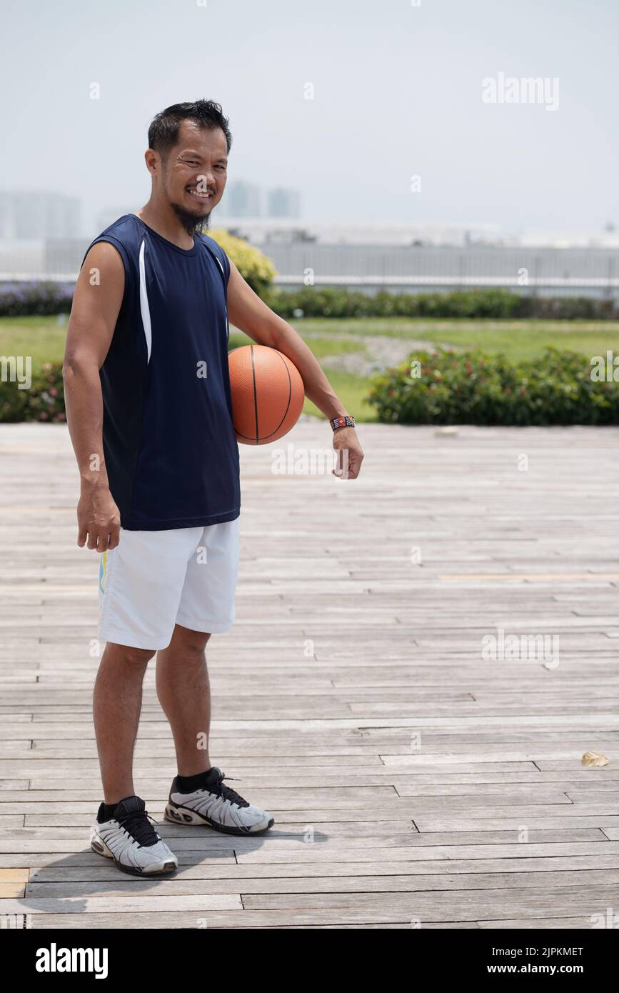 Filipino man with basketball ball playing outdoors Stock Photo - Alamy