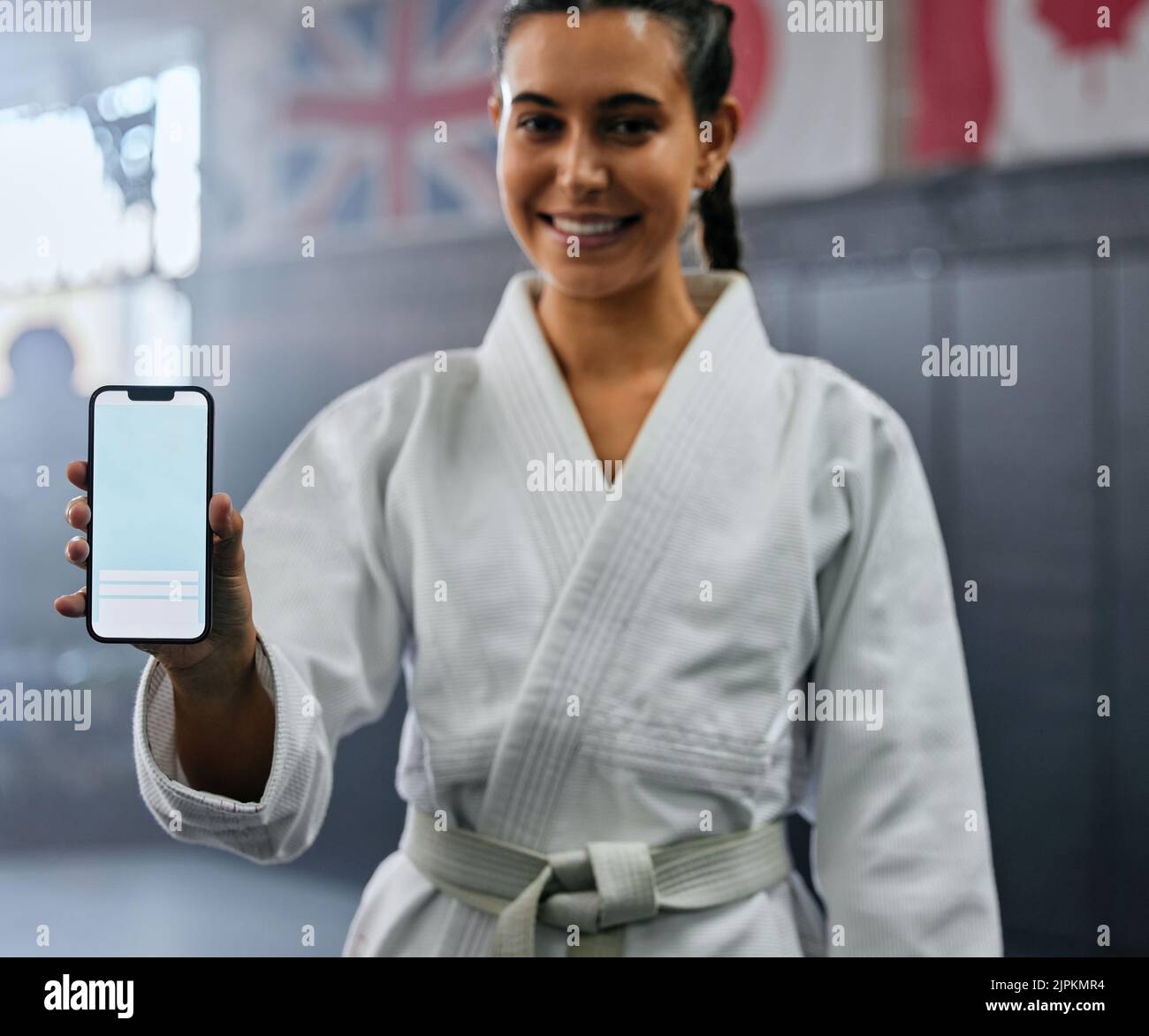 Portrait of a female karate student holding tech with social media ...