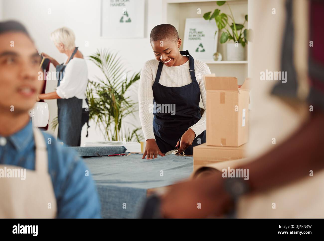 Fashion designer and creative stylist cutting fabric, sewing clothes ...